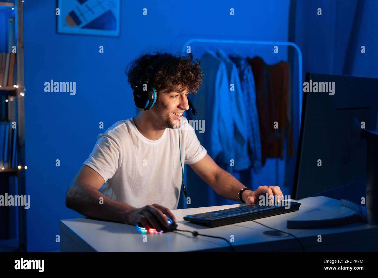 Happy young arabic gamer wearing headphones playing video game on ...