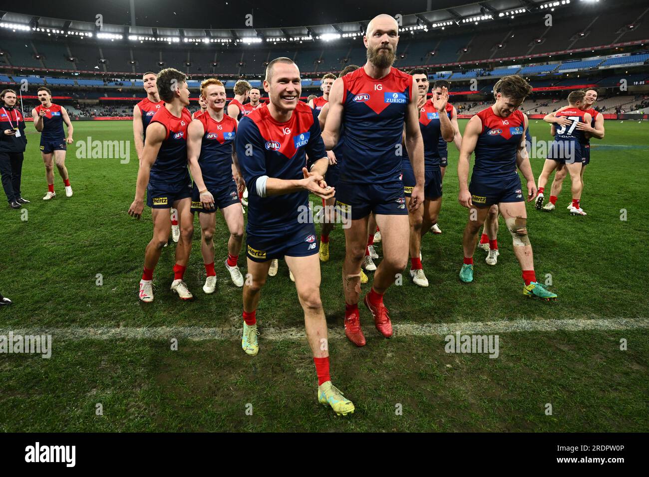 Ed Langdon of Melbourne (right) leads teammates from the field during ...