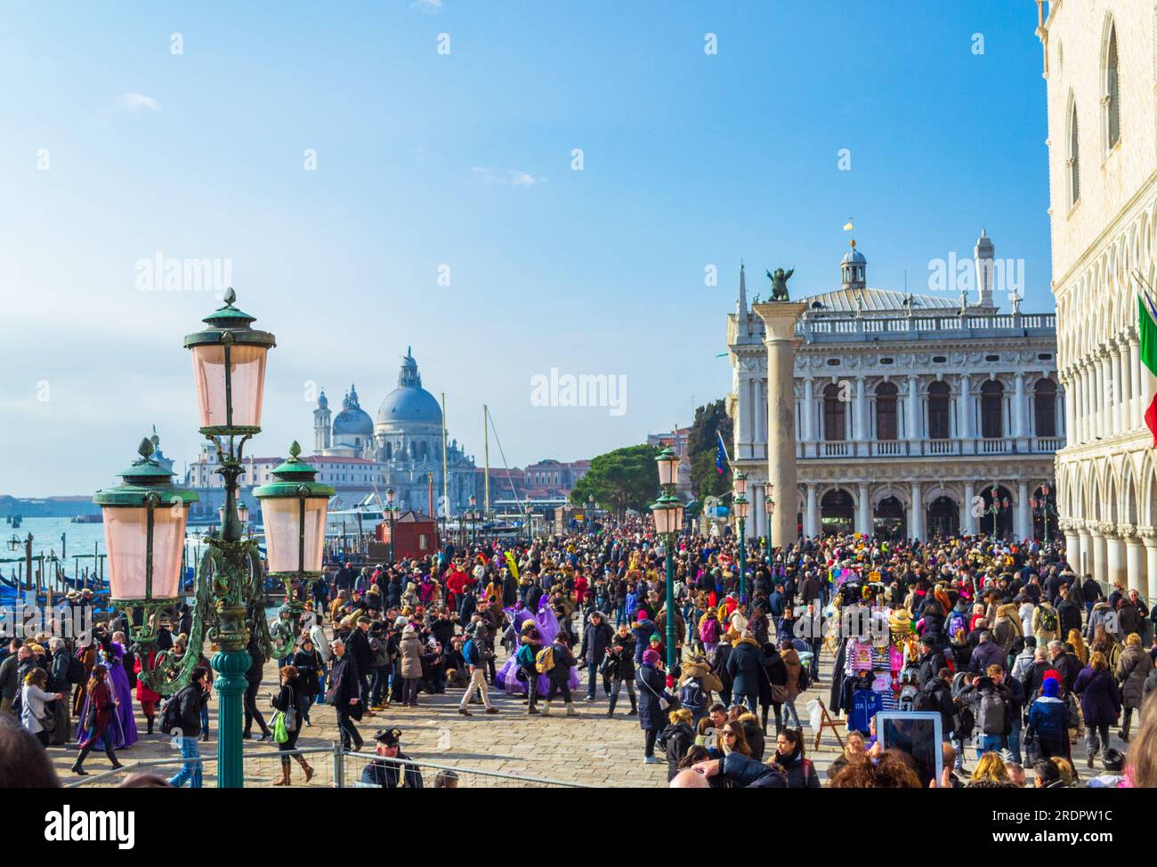 Crowded waterfront promenade of Venice during the traditional Carnival ...