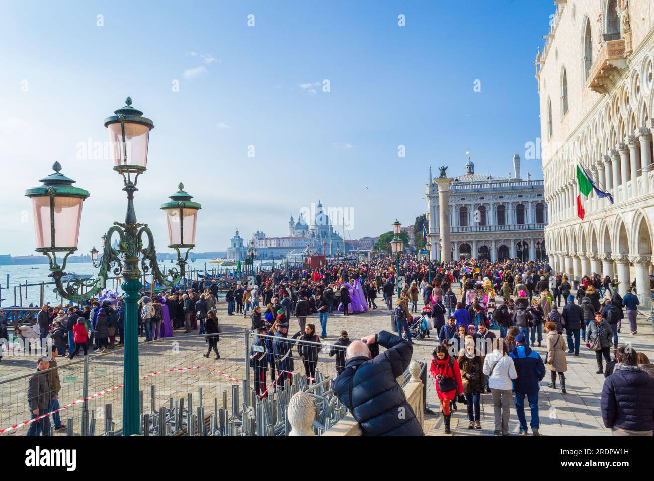 Crowded waterfront promenade of Venice during the traditional Carnival ...
