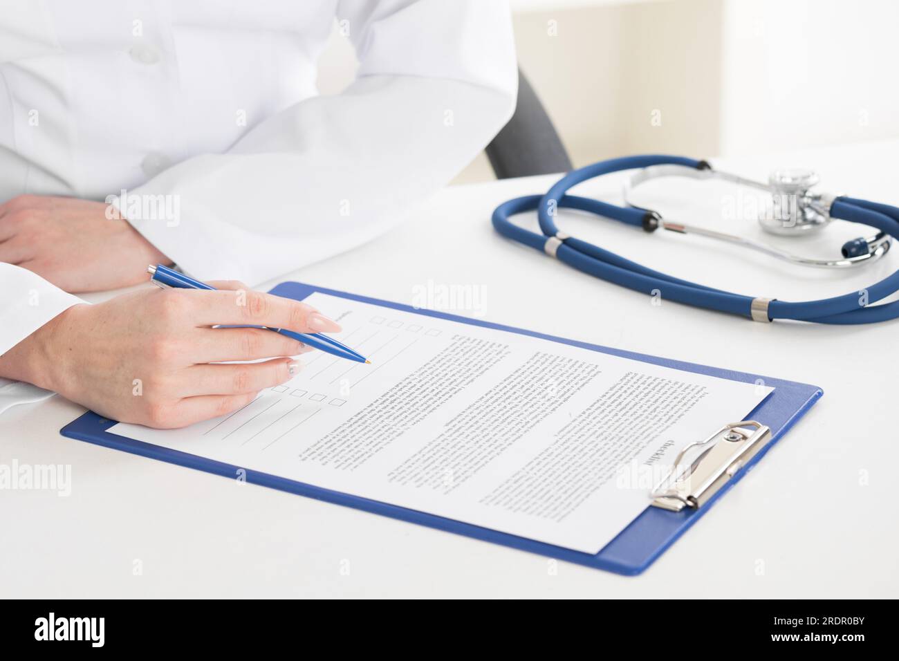 Female doctor hands writing on sheet in a clipboard with a pen Stock ...