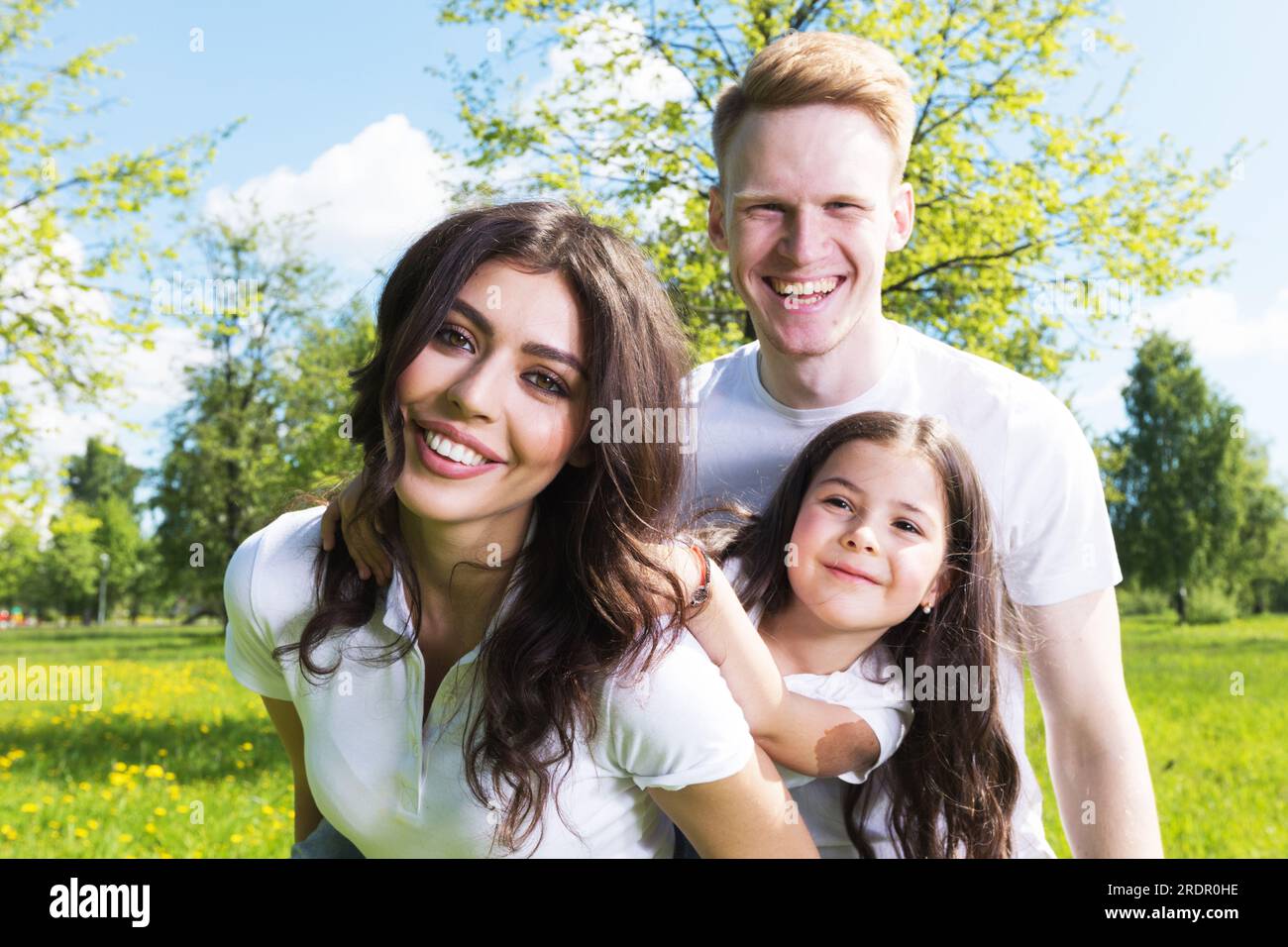 Happy family having fun outdoors in spring park against natural green ...