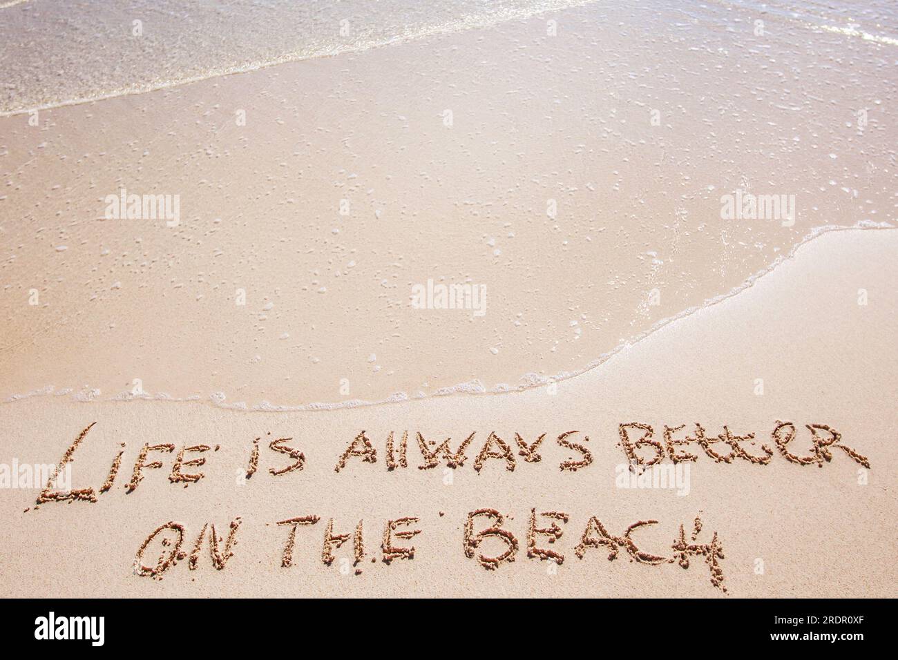 Life is always better on the beach written on the sand of tropical sea ...