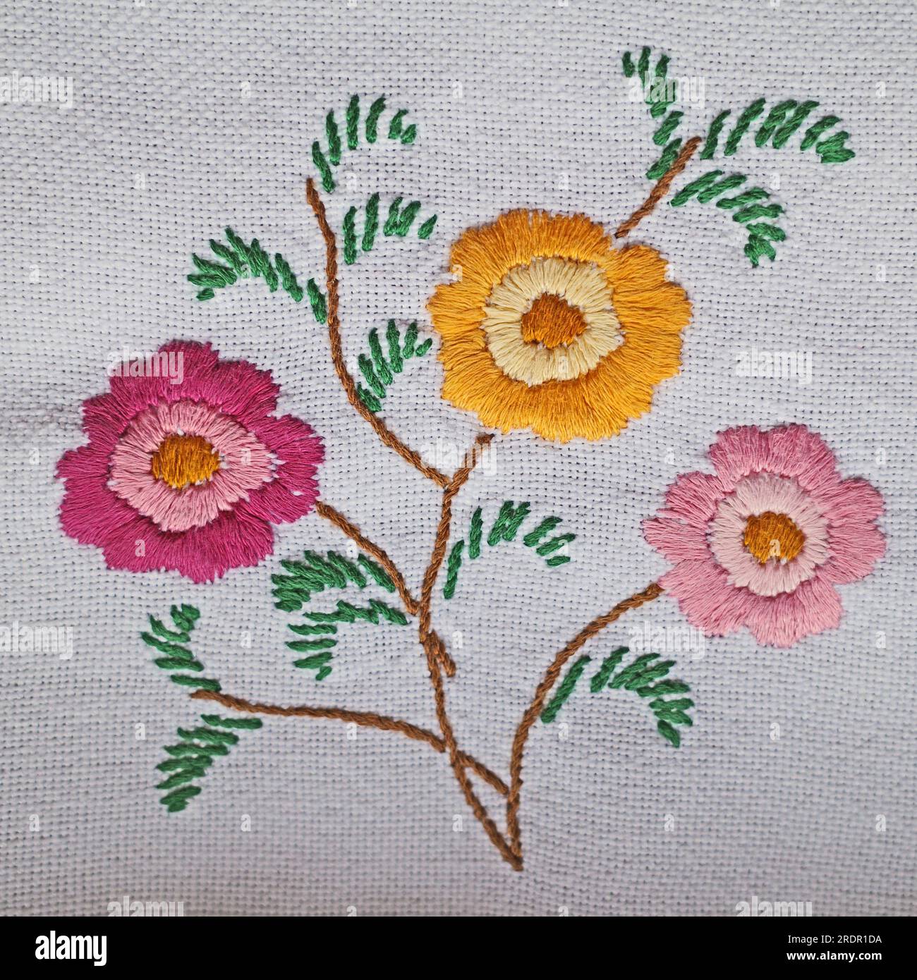 Embroidery bouquet of red, yellow and pink flowers and leaves on white ...