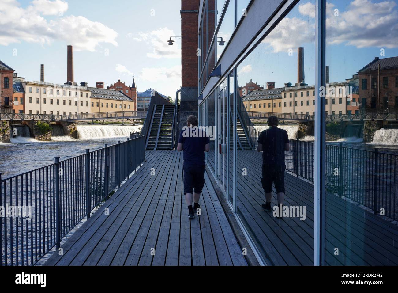 a person walks on a footbridge in a city Stock Photo - Alamy