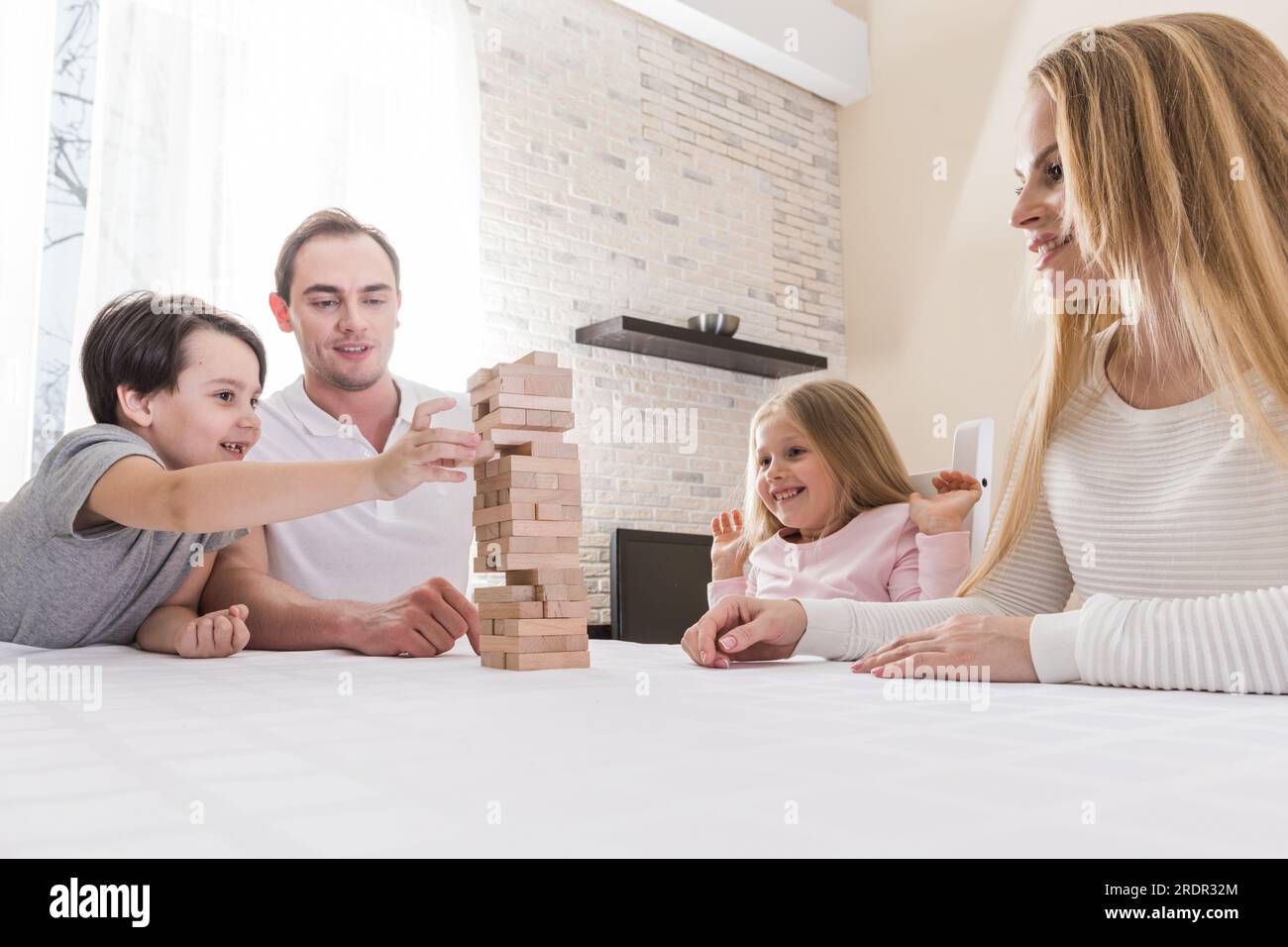 Happy family having fun playing Jenga, tower collapsing Stock Photo - Alamy