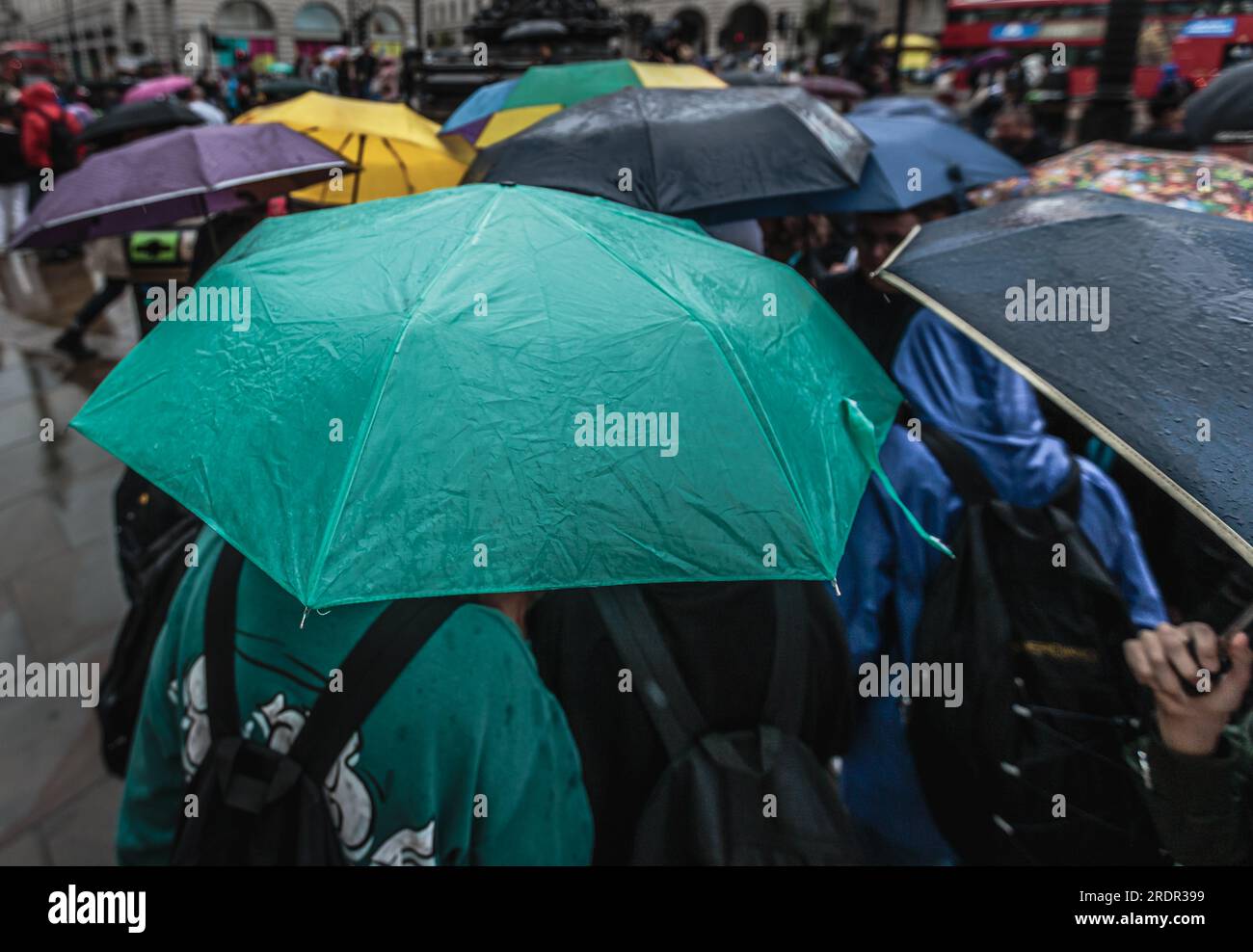 Sheltering under their brollies as the rain continues in London Stock ...
