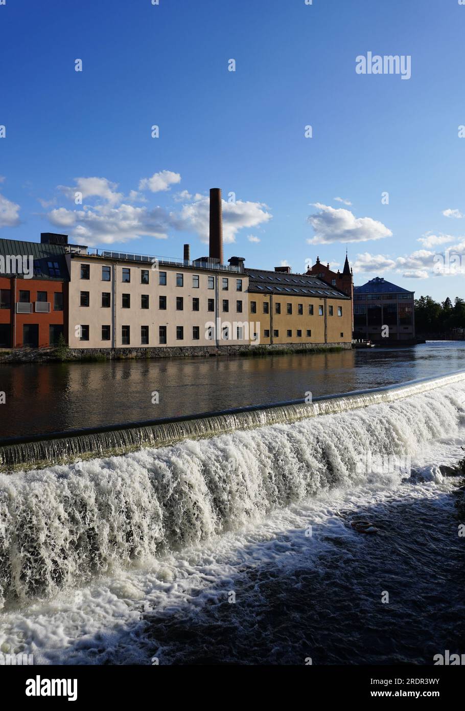 A waterfall next to industrial buildings Stock Photo - Alamy