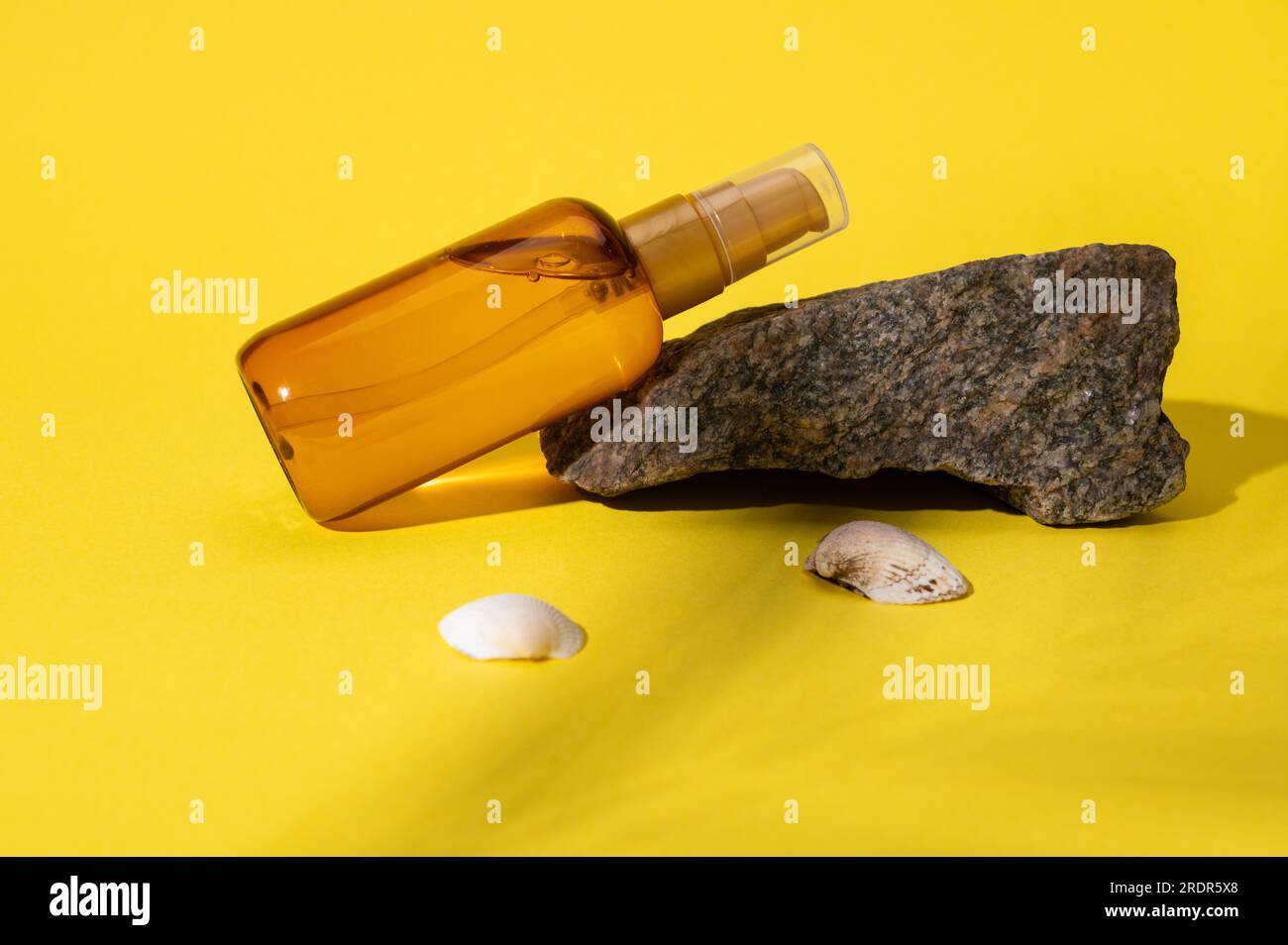 Still life with a transparent bottle with sunscreen lotion on a small ...