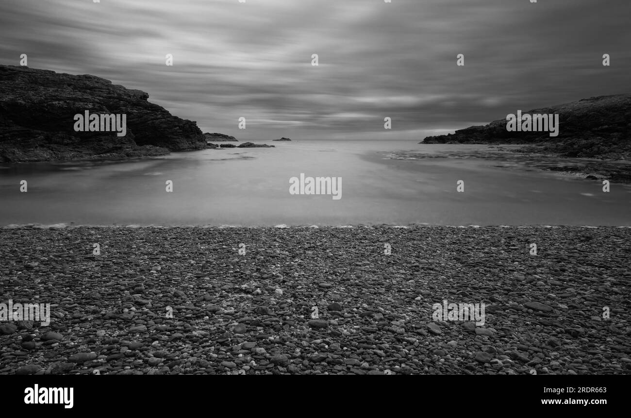 Long exposure. Smooth sea. Pebble beach foreground. Monochrome black ...