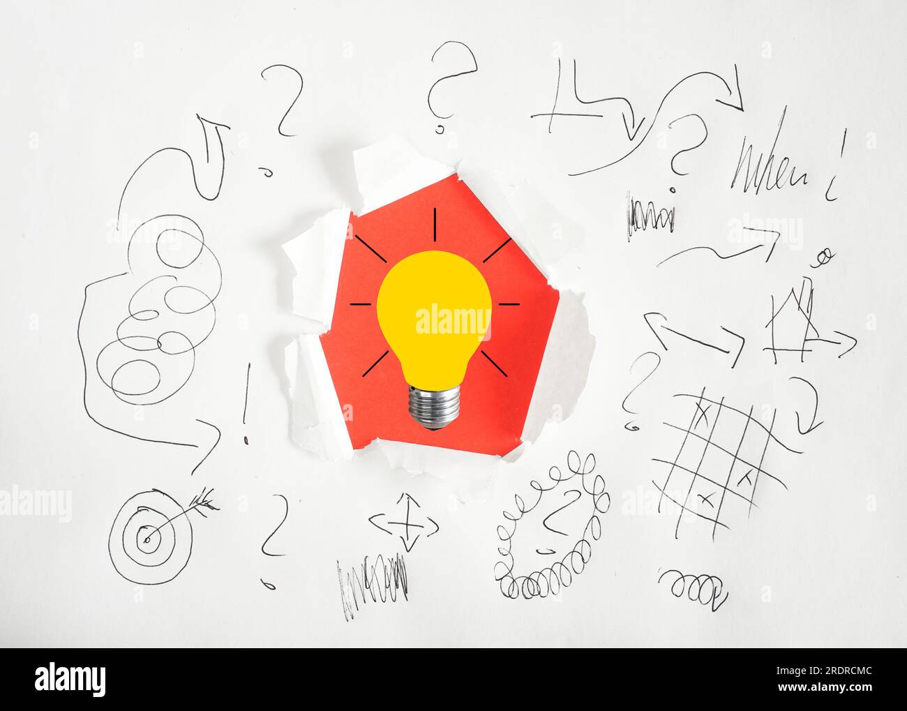 Lightbulb inside of punch paper with scribble and question marks for ...