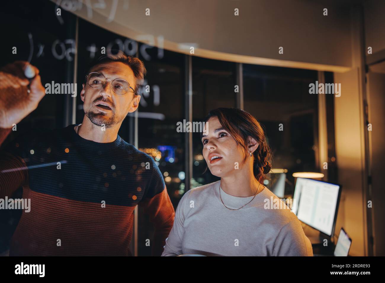 Team of business professionals collaborating in a late-night ...