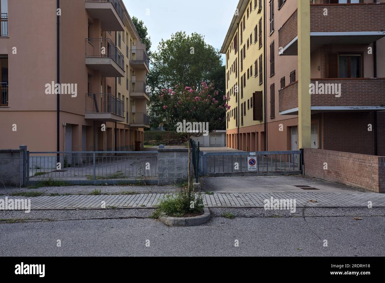 Gates and passageway between residential buildings seen from a street ...
