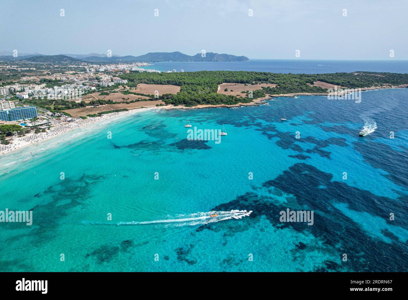 Aerial view of a Banana boat ride in Sa Coma beach in Mallorca, Spain ...