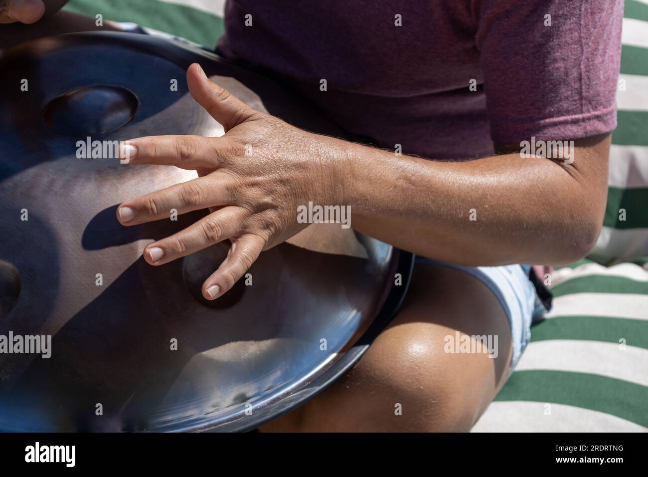 Man playing a percussion instrument called a handpan. Tibetan sounds ...