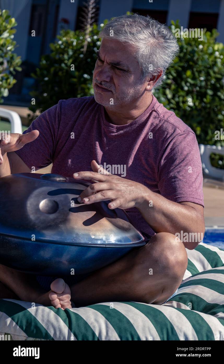 Man playing a percussion instrument called a handpan. Tibetan sounds ...