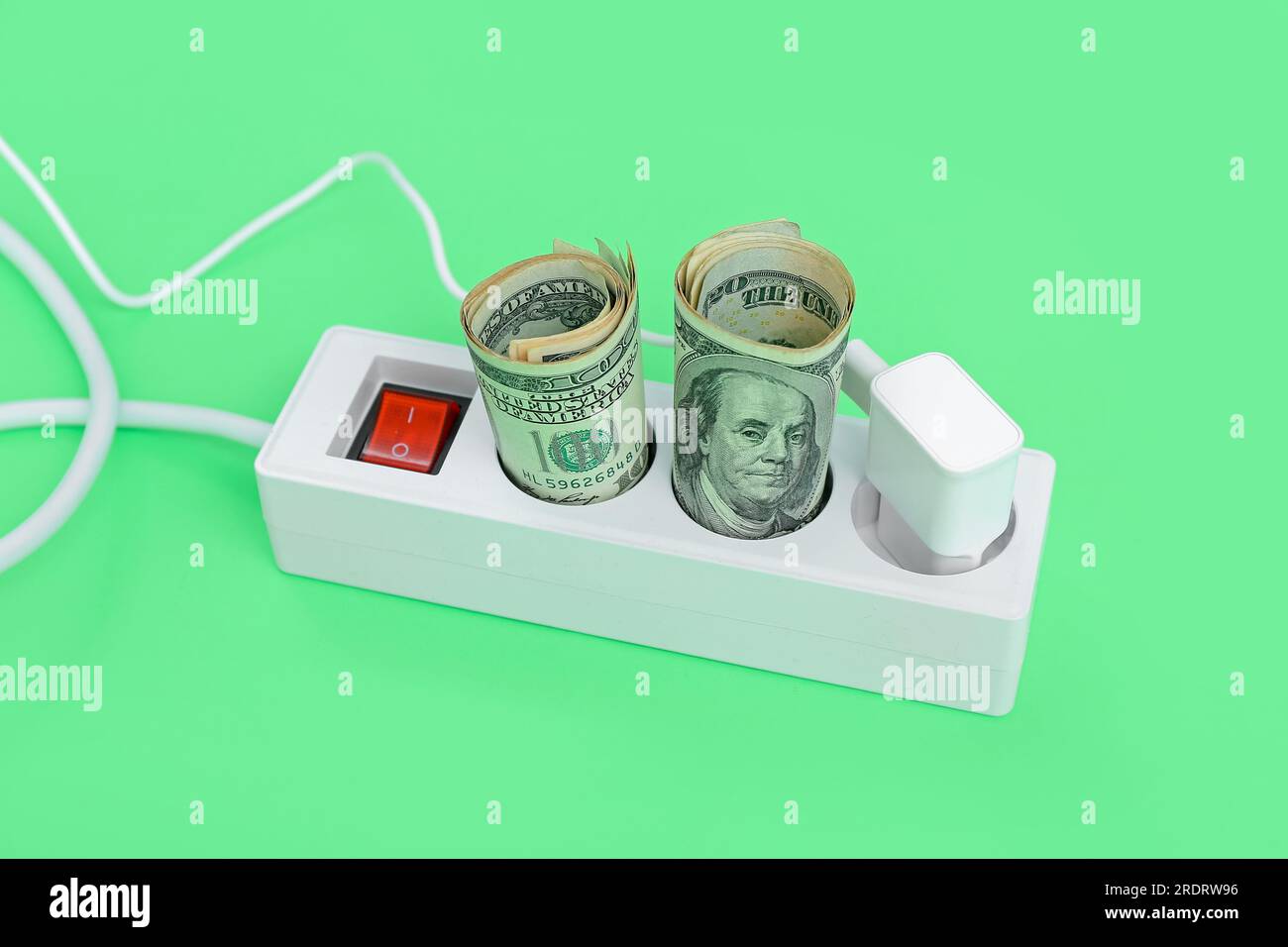 Power socket with plug and dollar banknotes on green background Stock ...