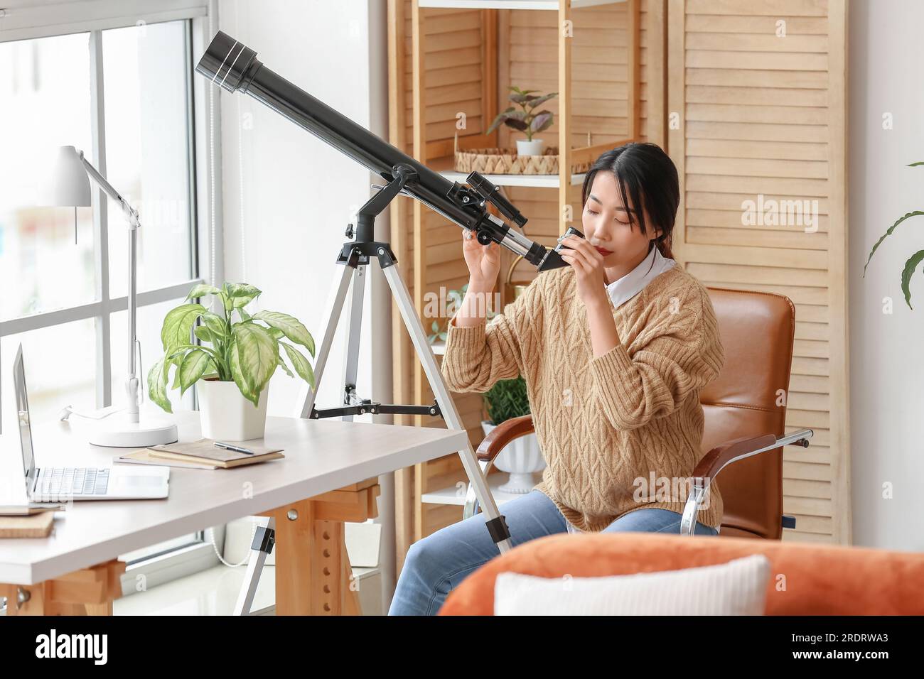Young Asian woman using telescope at home Stock Photo - Alamy