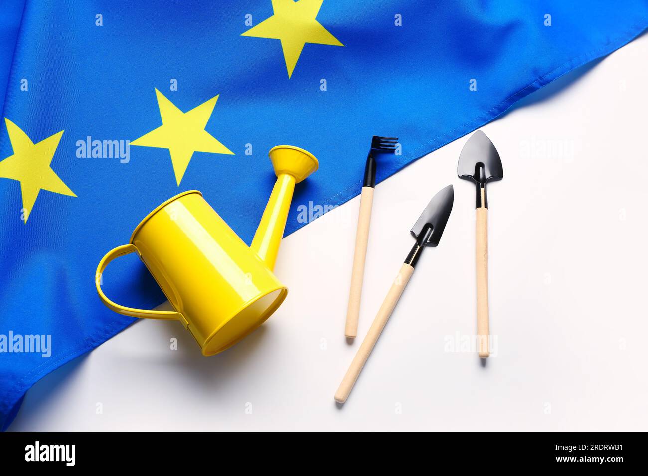 Flag of the European Union with watering can and gardening tools on ...