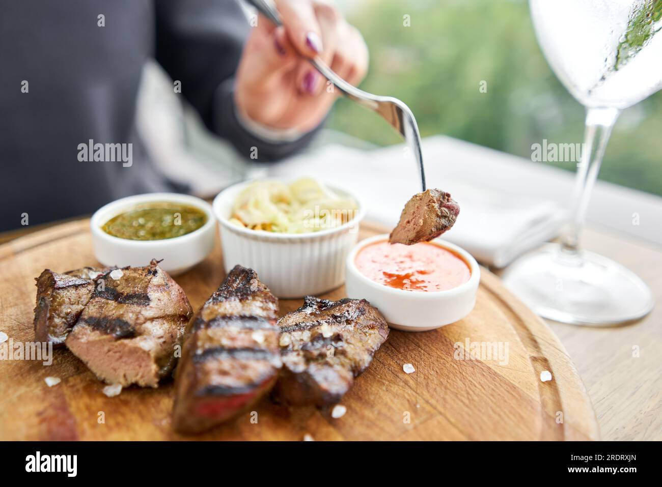 Lunch in a restaurant, a woman eats Pieces of liver cooked on the grill ...