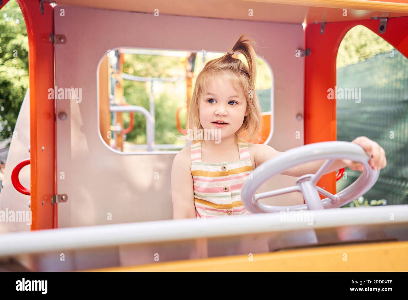 Little girl playing, she is a car driver holding steering wheel on ...