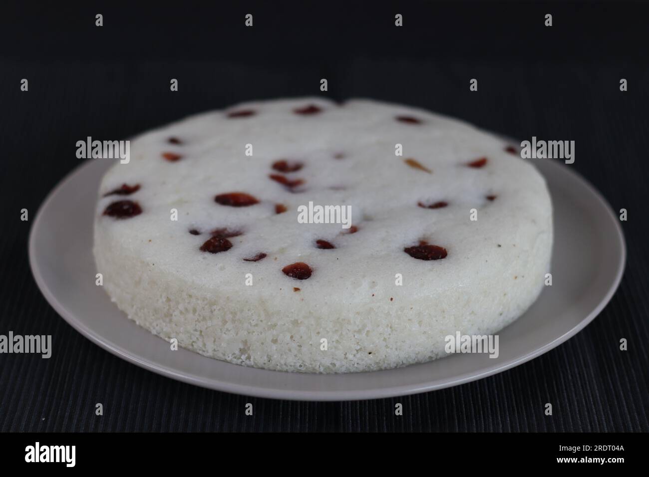 Vattayappam. Steamed spongy rice cake topped with dried cranberries. A ...