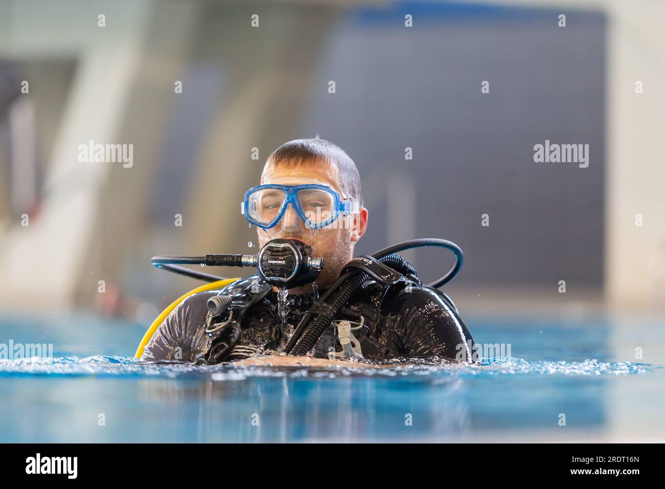 Sub-aqua diver wearing goggles at the water surface in an indoor ...