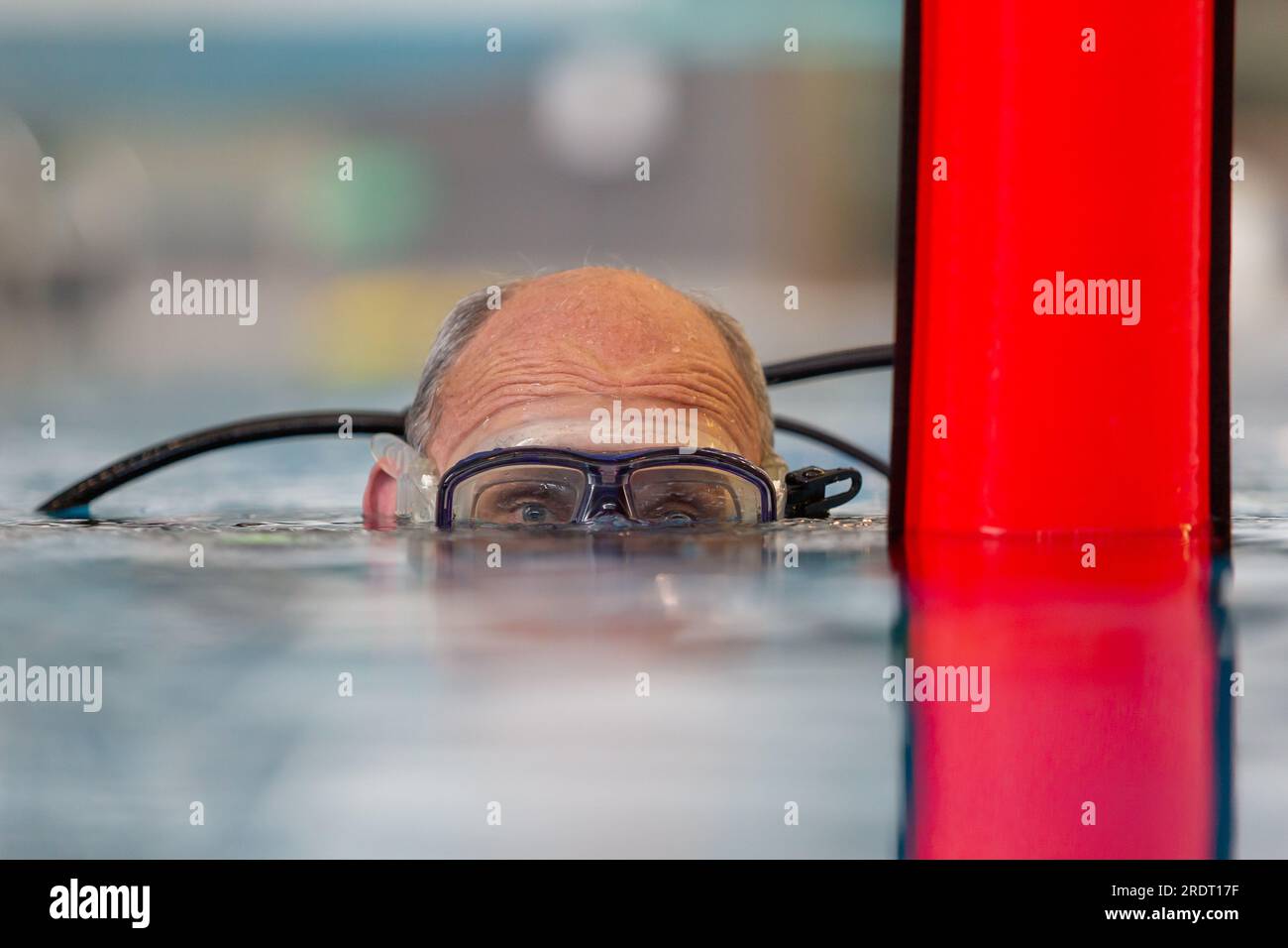 Sub-aqua diver wearing goggles at the water surface in an indoor ...