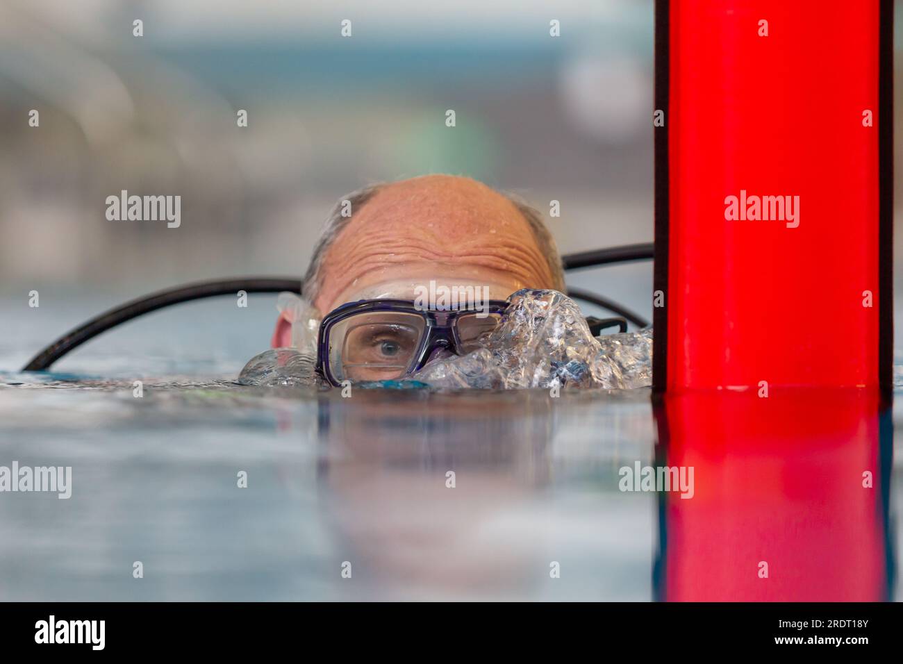 Sub-aqua diver wearing goggles at the water surface in an indoor ...