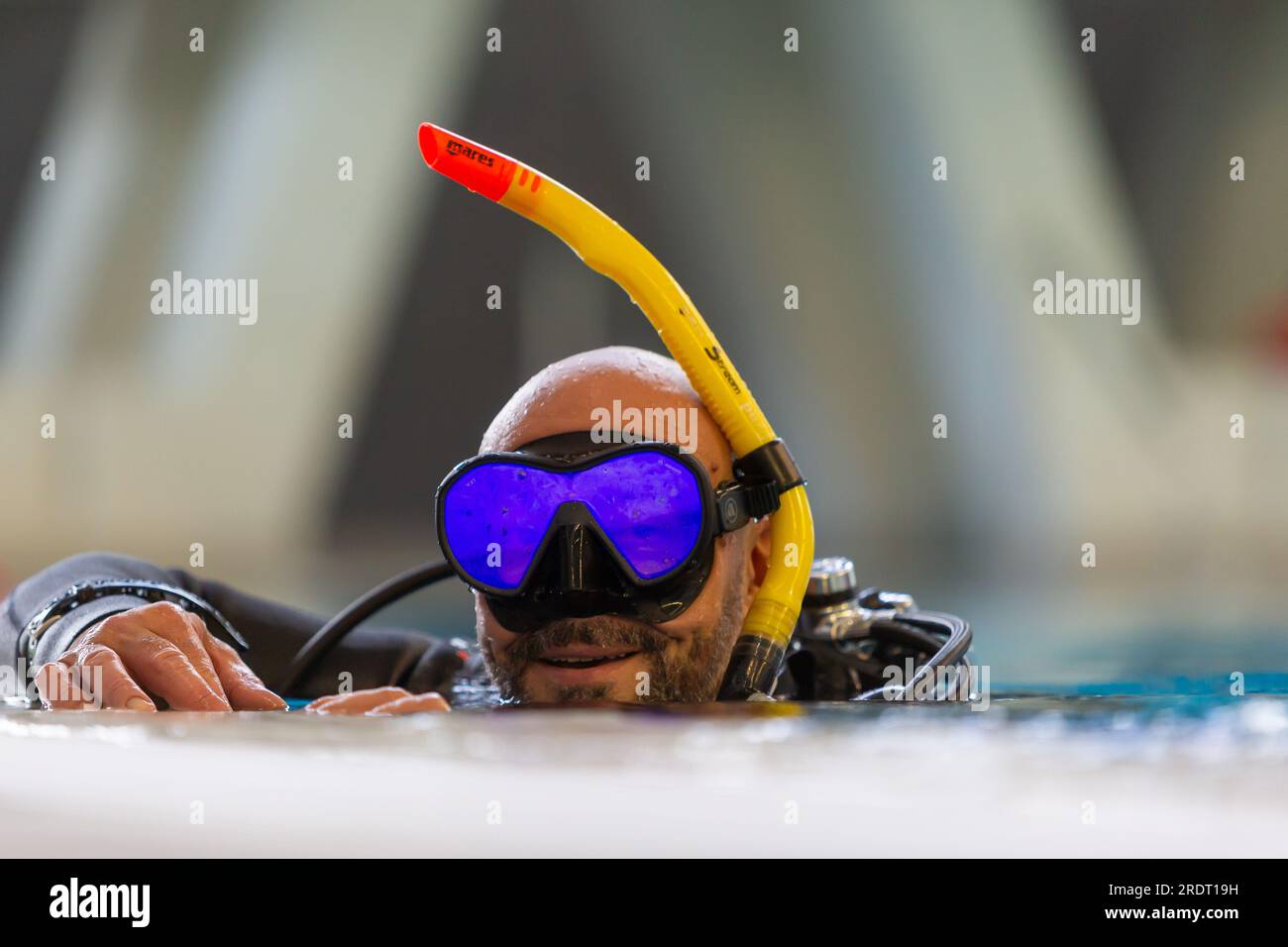 Sub-aqua diver wearing goggles at the water surface in an indoor ...