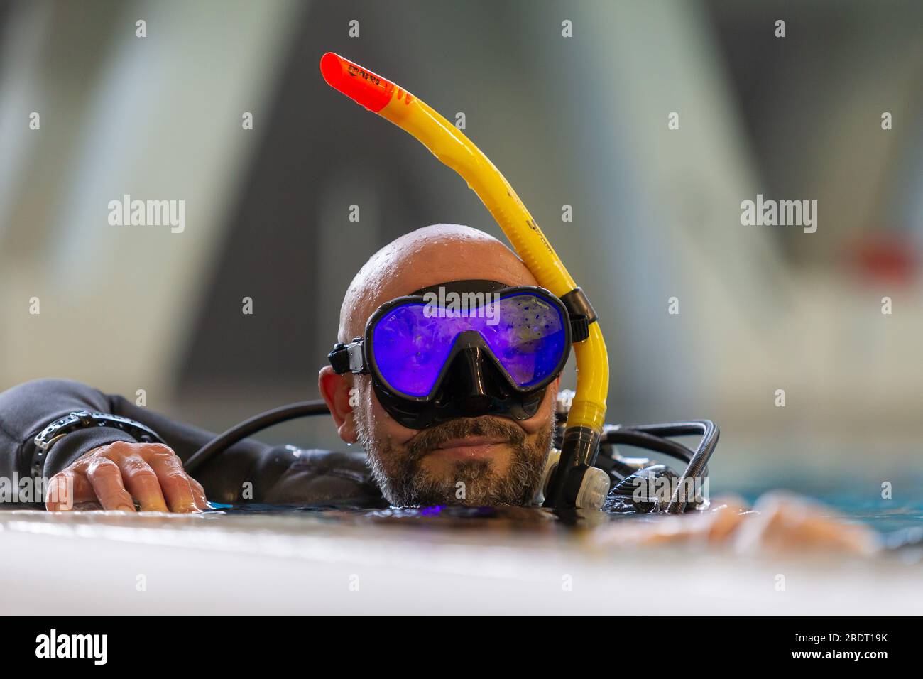 Sub-aqua diver wearing goggles at the water surface in an indoor ...