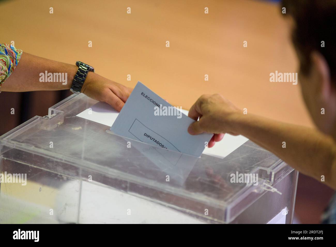 Madrid, Spain. 23rd July, 2023. A woman enters her ballot into a ballot ...