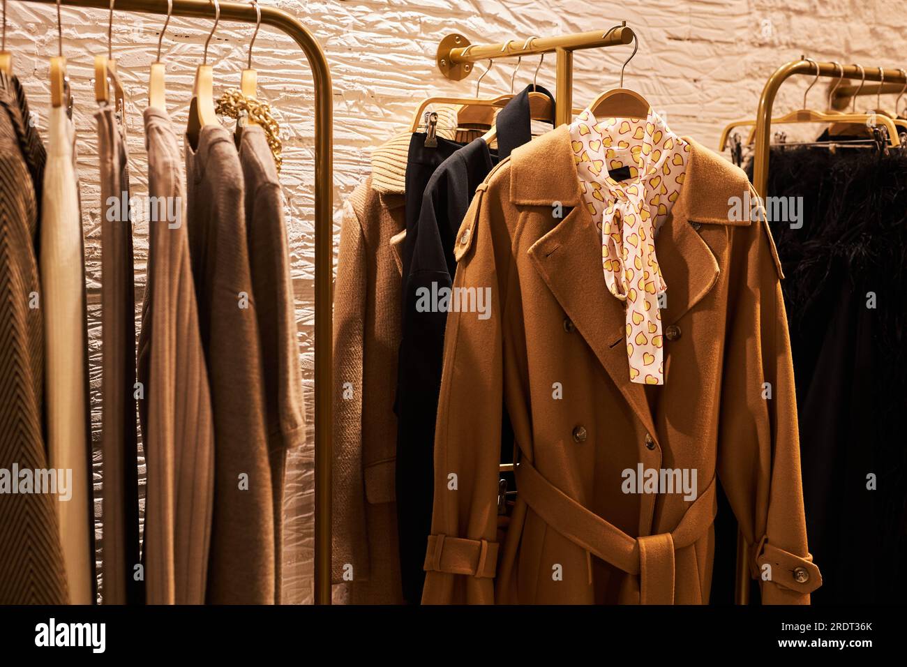 Warm toned background image of various coats collection on rack in ...