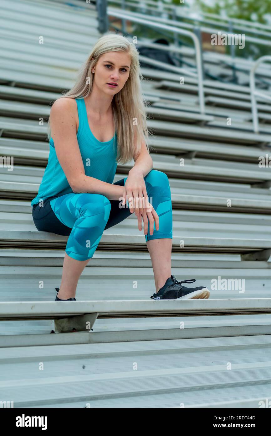 A beautiful young college athlete prepares herself for a track meet at ...