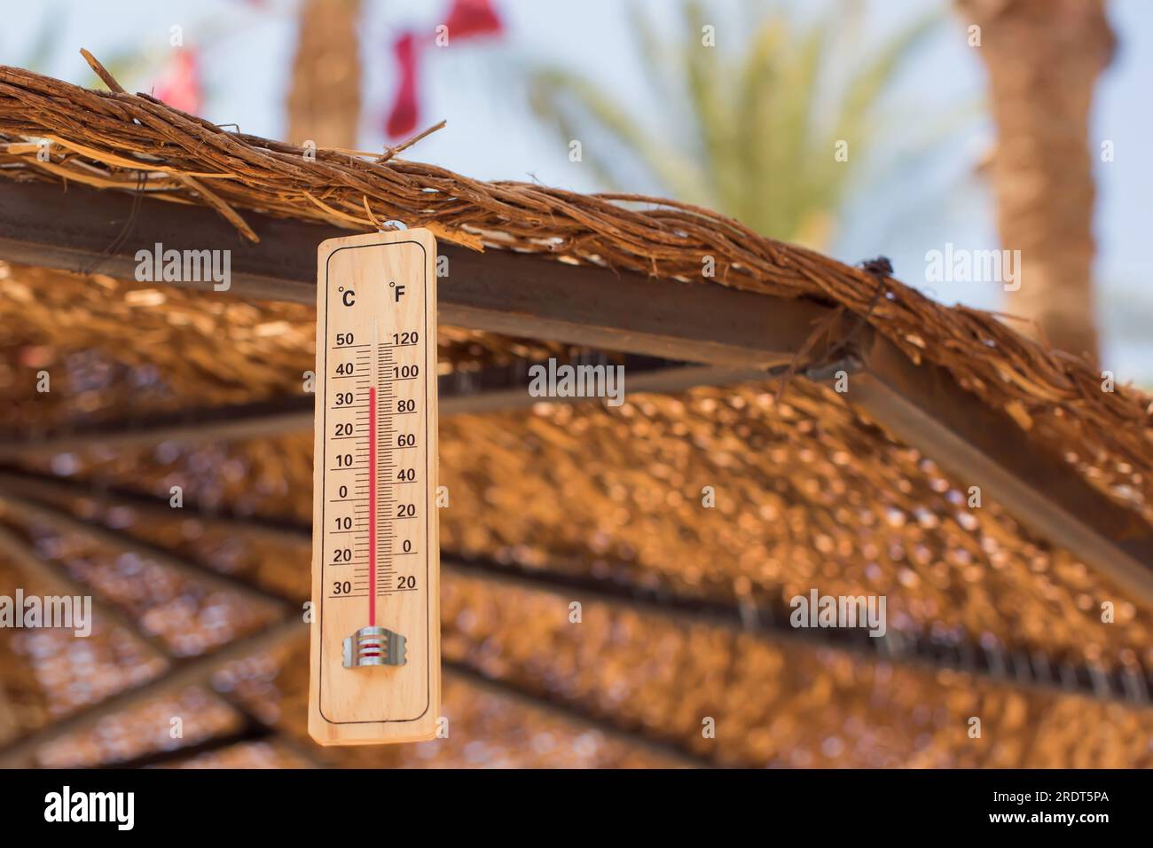 Thermometer on a parasol showing high temperature. Hot weather and ...