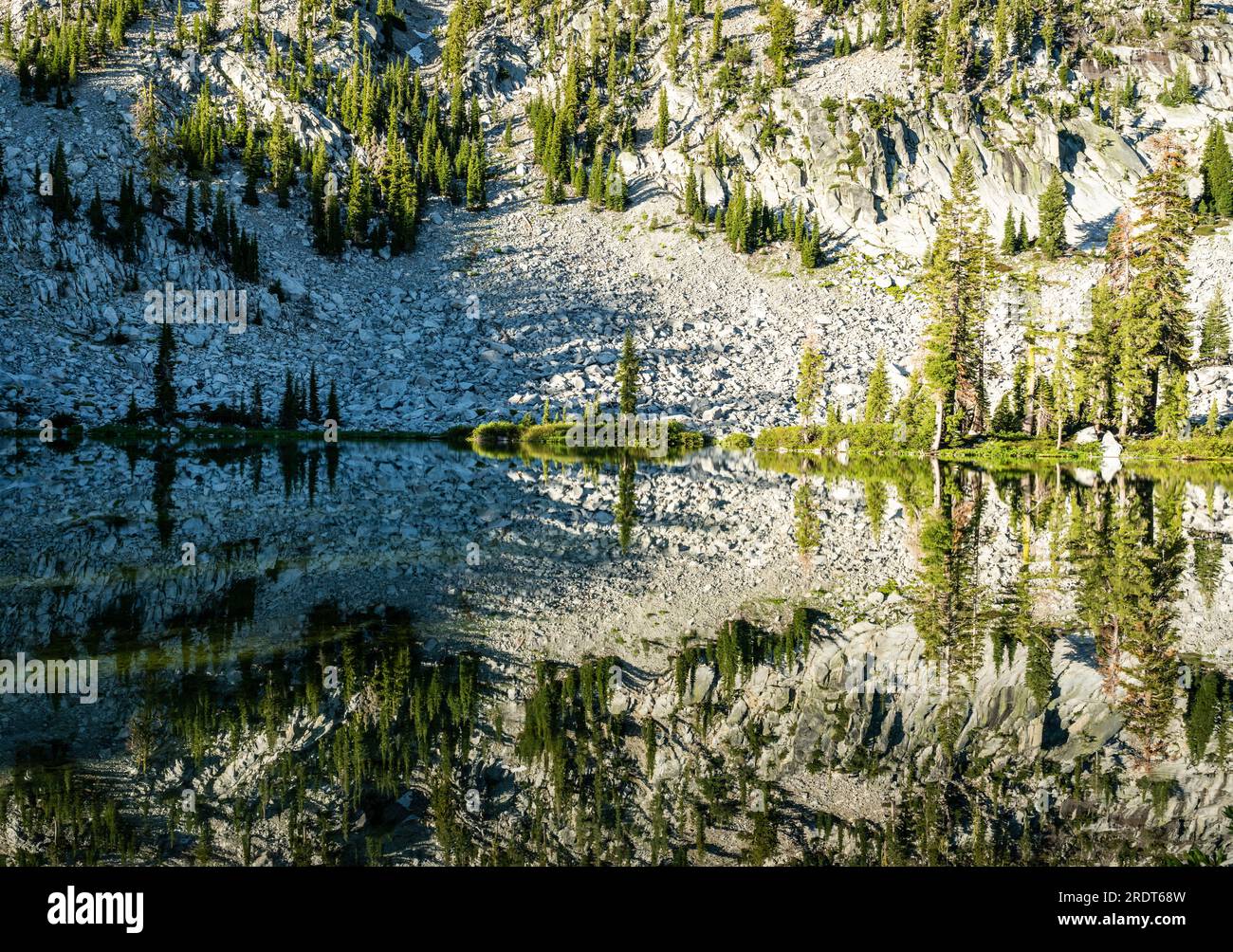 Still Water Mirrors The Rock Wall and Trees of Cliff Lake in Lassen ...