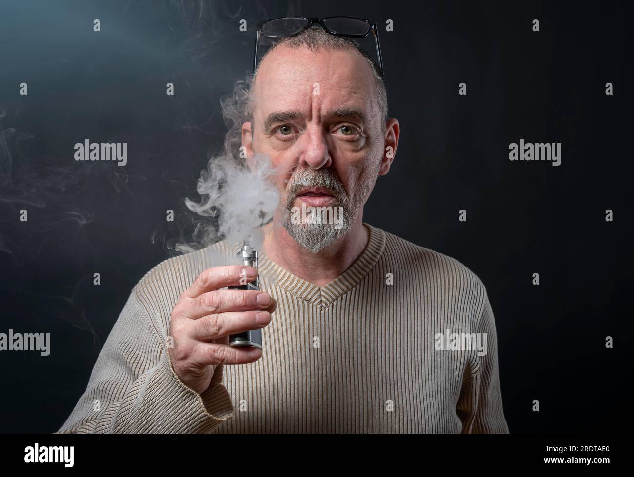 Portrait of a man with beard who is vaping Stock Photo - Alamy