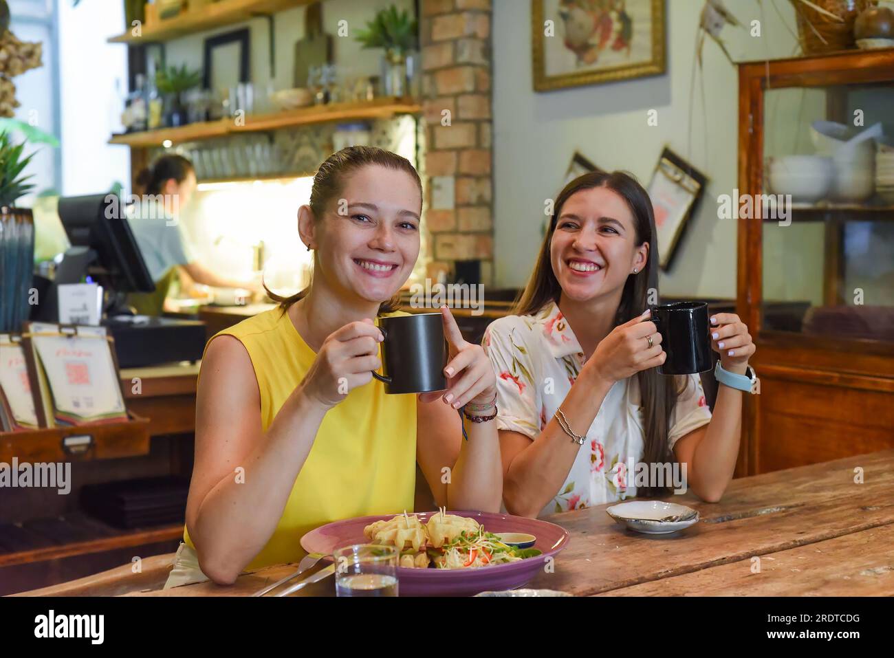 Two best friends talking and eating in a cafe Stock Photo - Alamy
