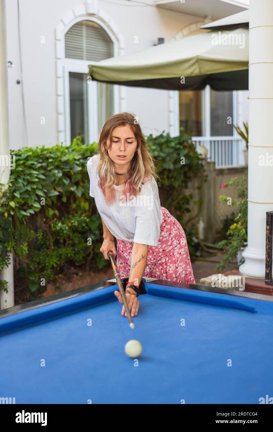 Young blond woman playing billiards in the backyard Stock Photo - Alamy