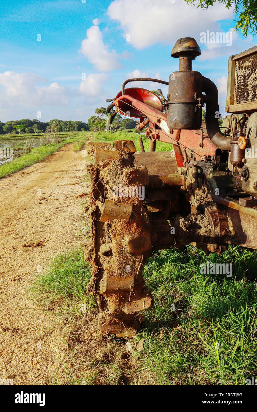 Old rusty tractor on the field with blue sky background Stock Photo - Alamy