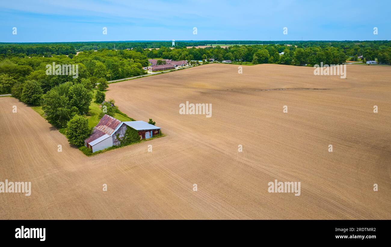 High up aerial view of empty dirt farmland with brown scar on land and ...