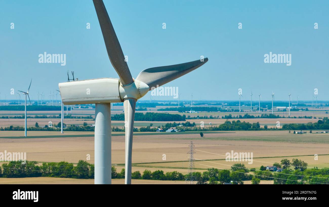 Close up of wind turbine propellers with wind farm in background aerial ...