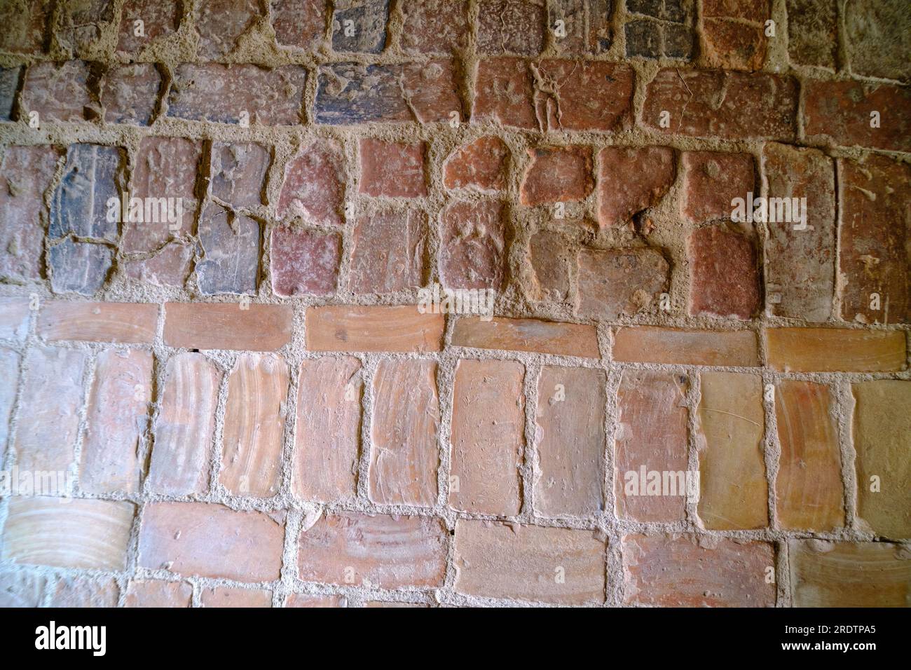 Close-up of an old brick-paved farm interior. Clay brick paving pattern ...