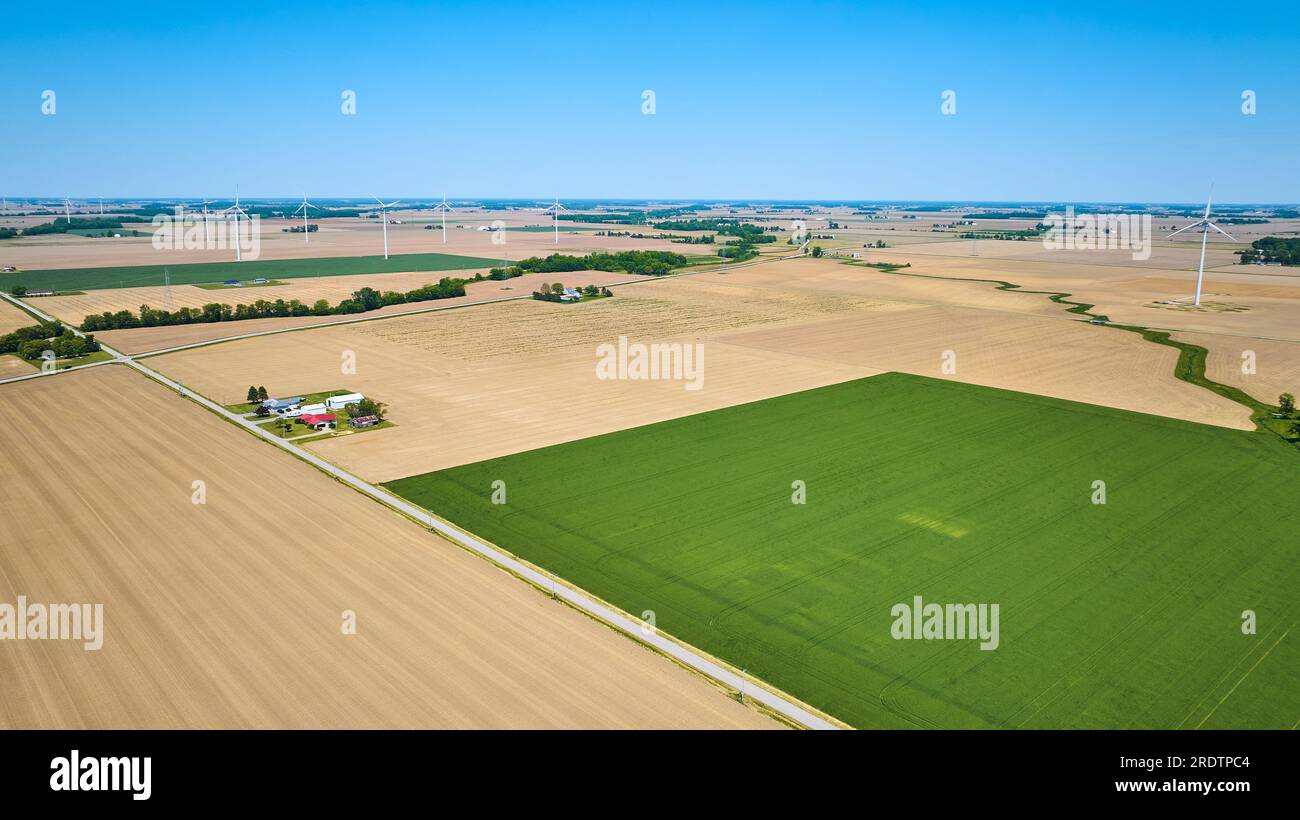 Aerial wind farm in barren farm land with mostly empty fields and some ...