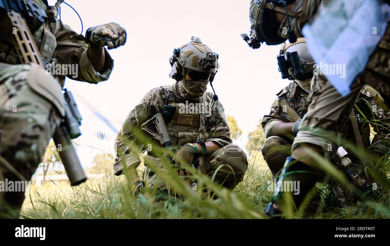 Squad of soldiers running forward and attacking enemy during military ...