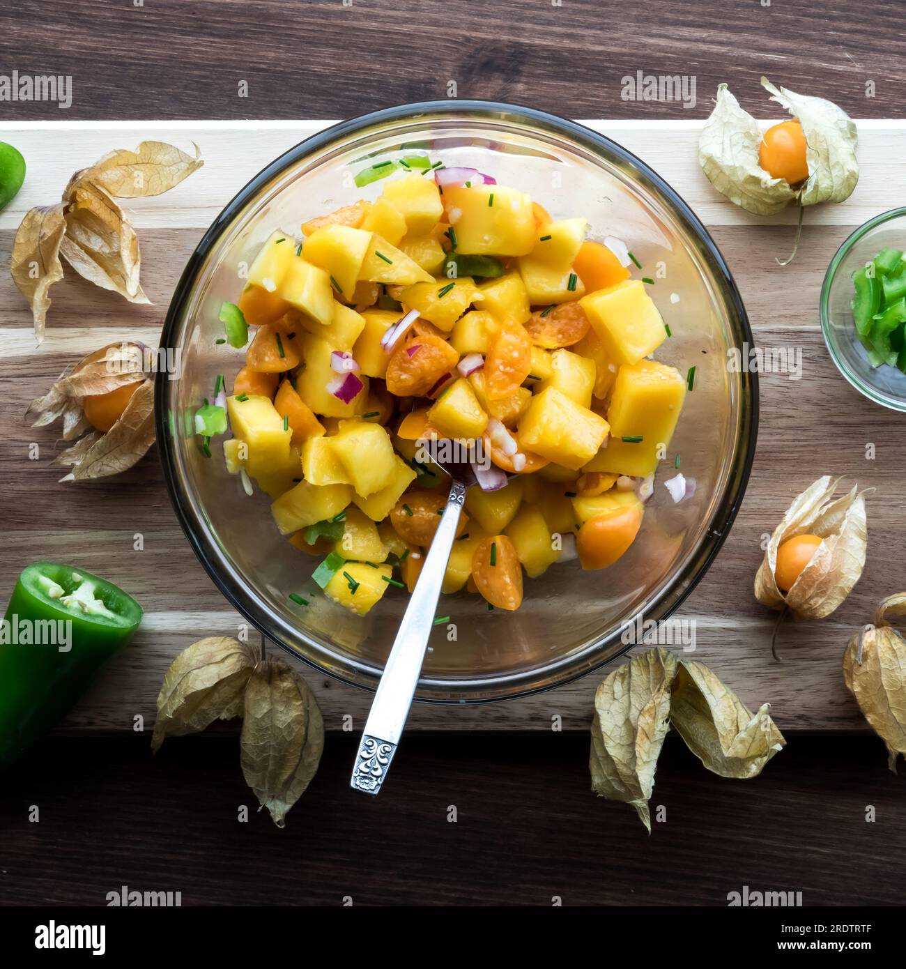 Top down view of a bowl golden berry and mango salsa, ready for serving ...