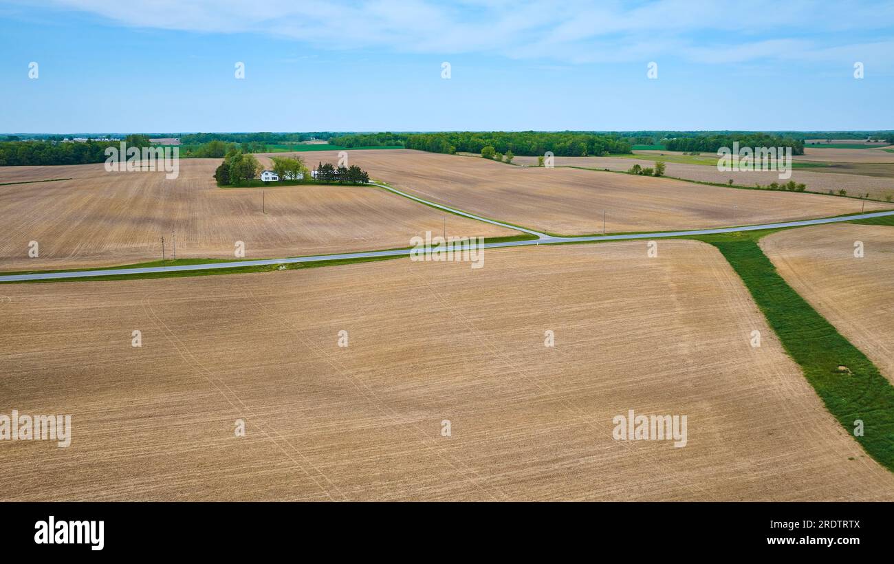 Clean farm landscape property aerial with green runoff ditches, paved ...