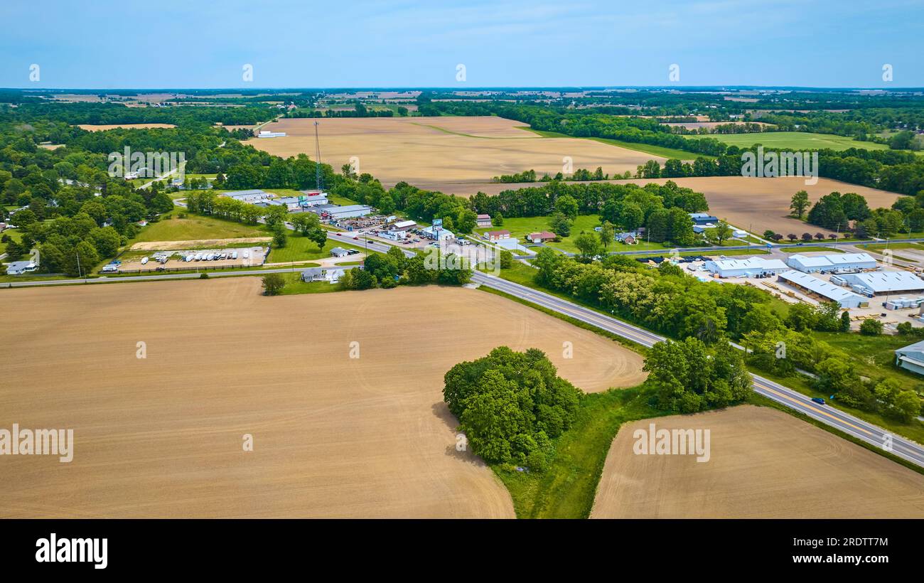 Aerial of small town with lots of barren fallow farmland and green ...