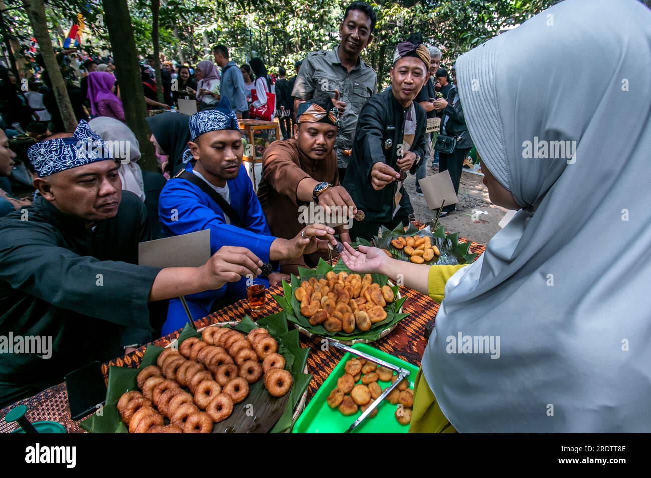 Buyers pay for snacks of fried cassava with coconut shell chips worth ...