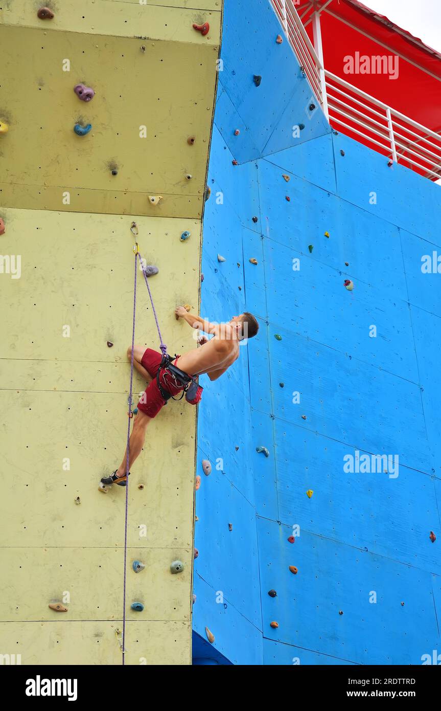 Muscular man climbing on a big wall Stock Photo - Alamy